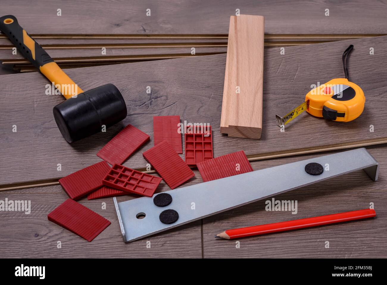Planks of laminate floor and equipment or tools to install them, hammer ...