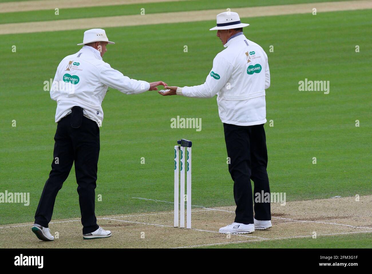 Umpire David Millns (R) and Michael Burns check the light with a meter ...