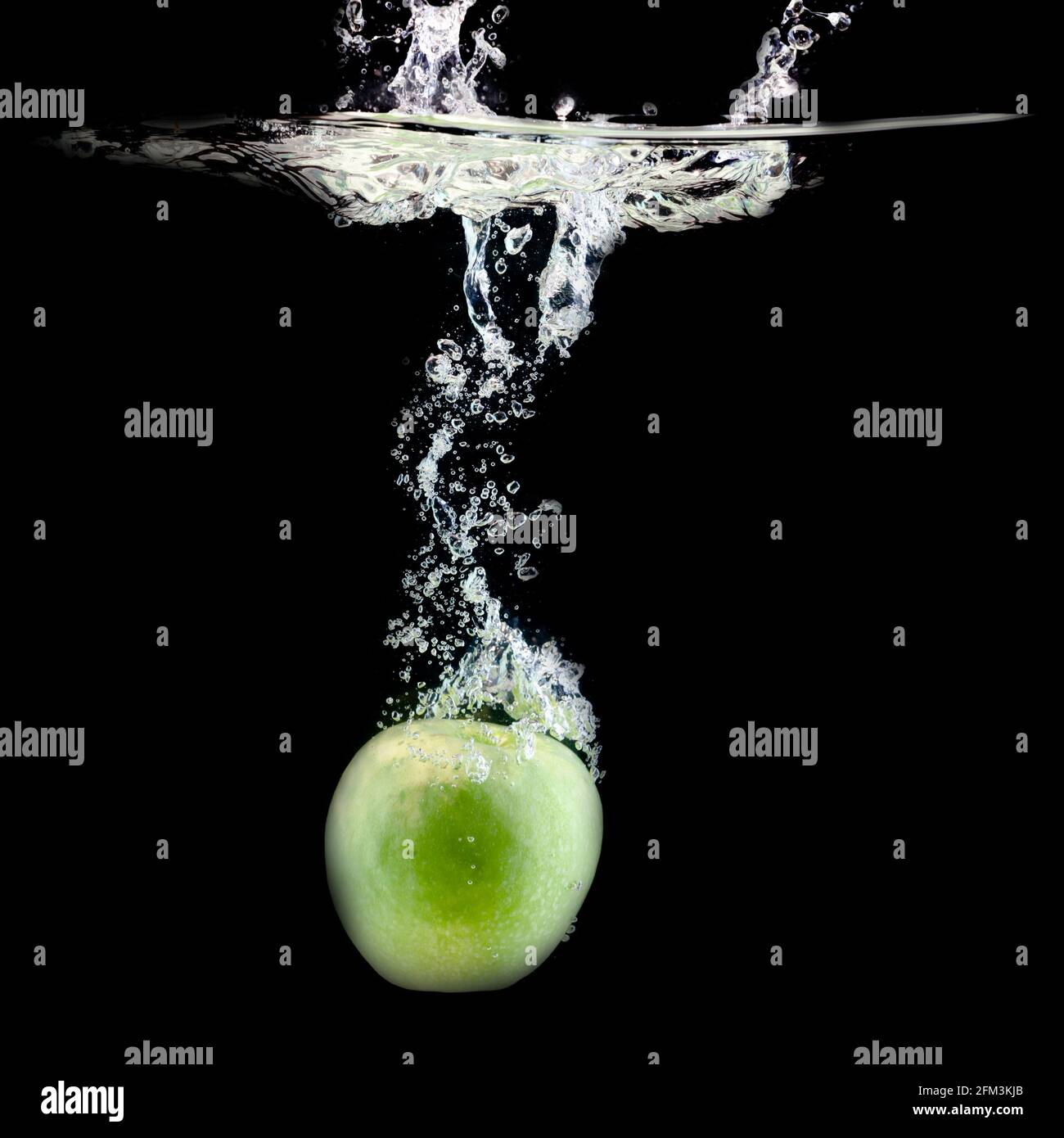 green apple fell into the water with splashes Stock Photo - Alamy