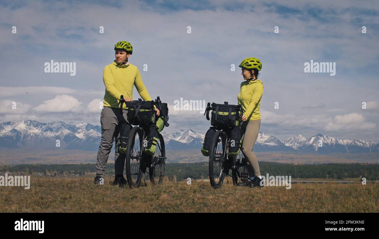 The man and woman travel on mixed terrain cycle touring with ...