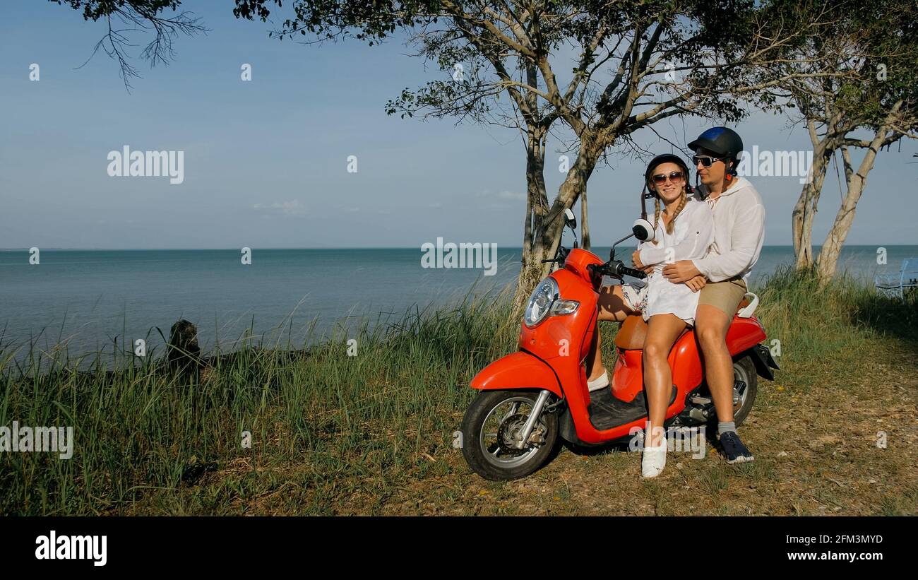 Scooter road trip. Love couple on red motorbike in white clothes on ...