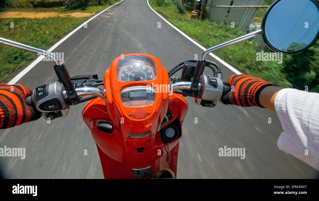 Scooter road trip. POV view, first person. Men on red motorbike in ...