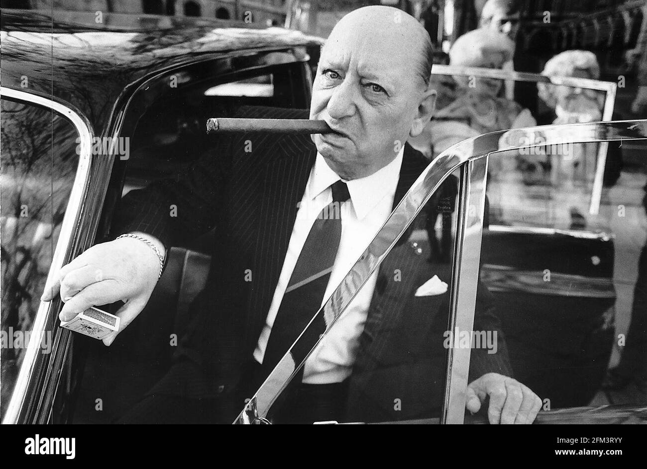 Lew Grade entertainment chief getting in a car while smoking a cigar ...
