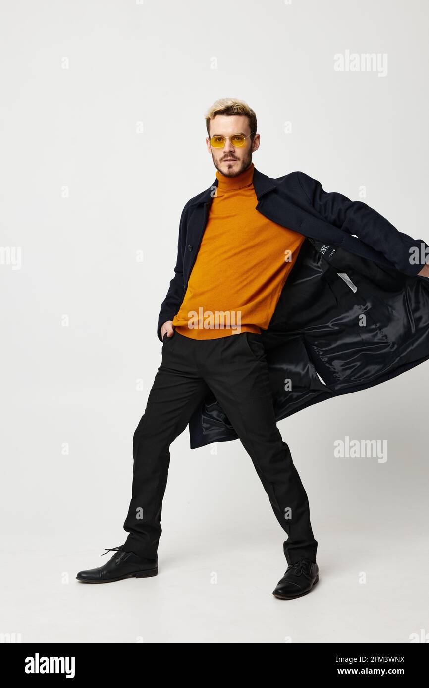 Energetic man posing in fashionable clothes on a light background ...