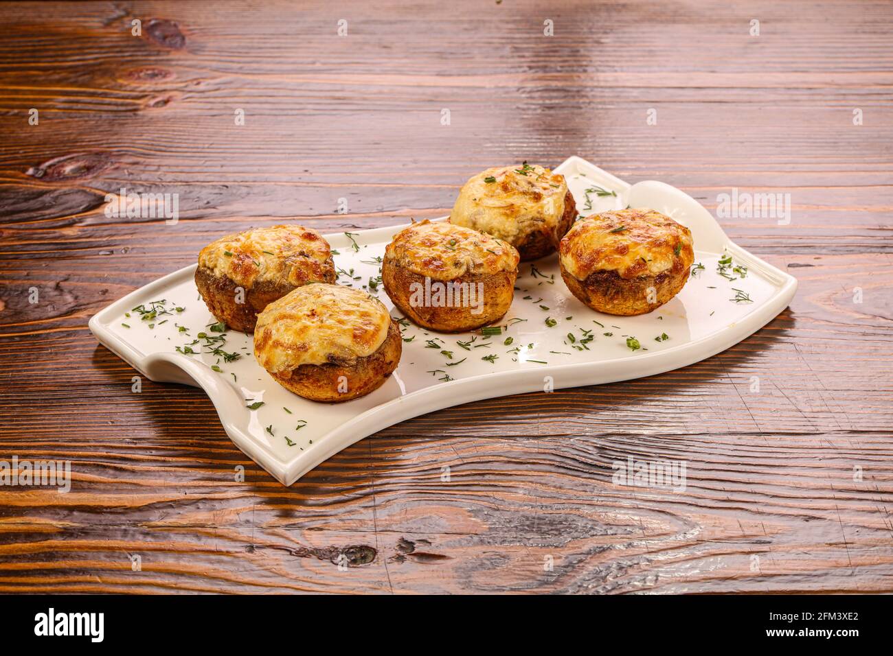 Baked champignon with cheese and green herbs Stock Photo - Alamy