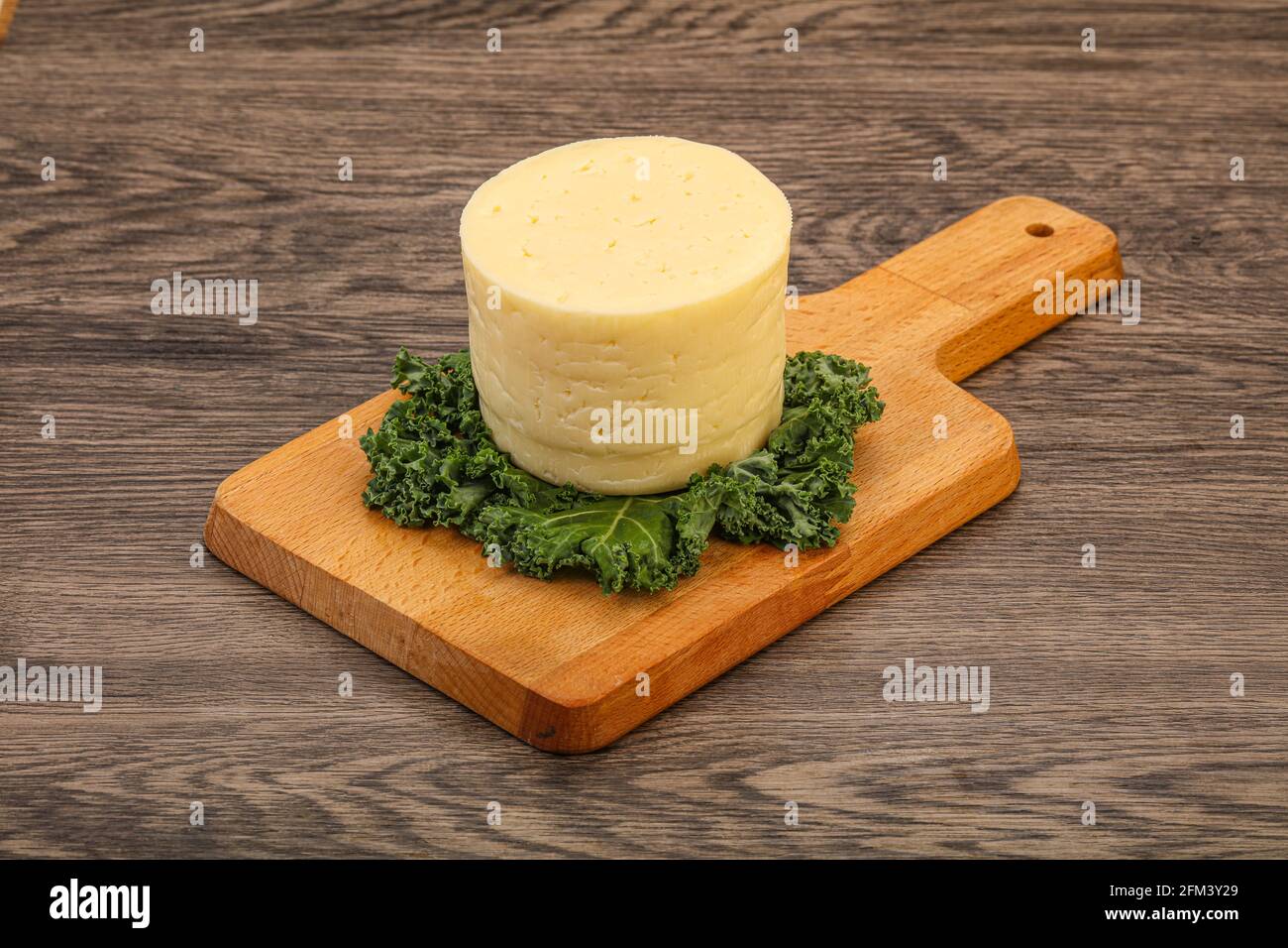 Yellow round dairy soft cheese piece Stock Photo - Alamy