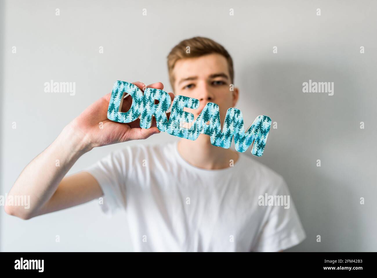 a smiling dreaming guy, young man laying on the blue couch at home. in ...