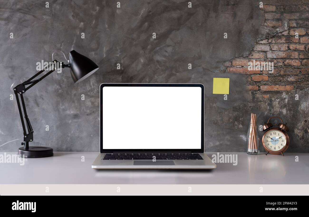 White desk with laptop computer blank white screen, lamp, office ...