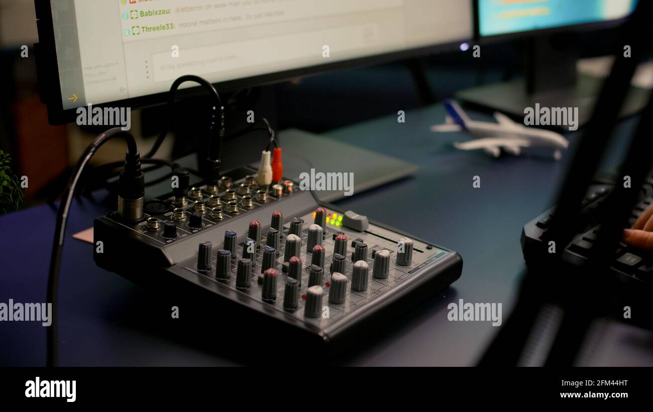 Close-up of streamer checking sound using professional mixer for ...