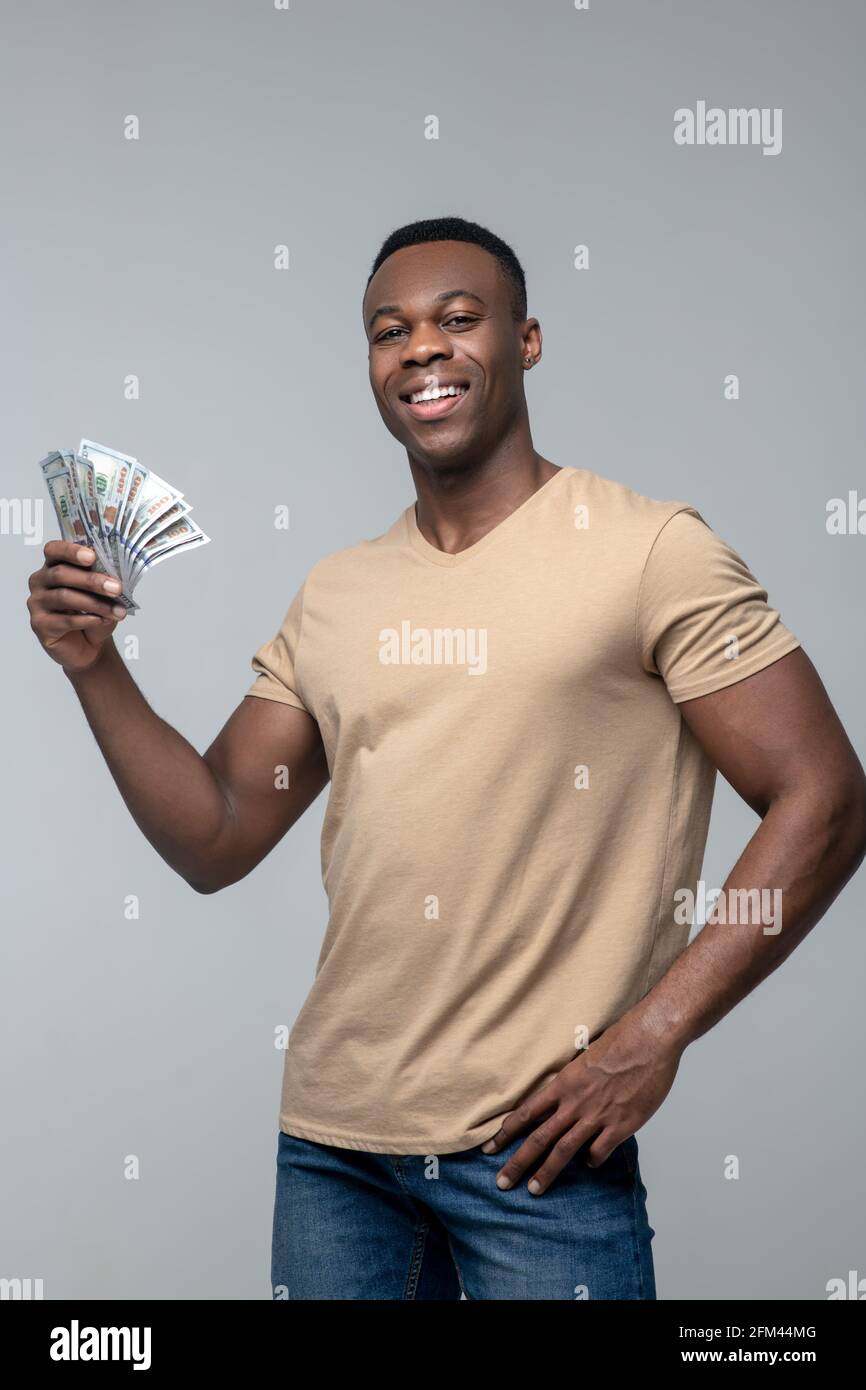 Joyful african american standing with banknotes in hand Stock Photo - Alamy