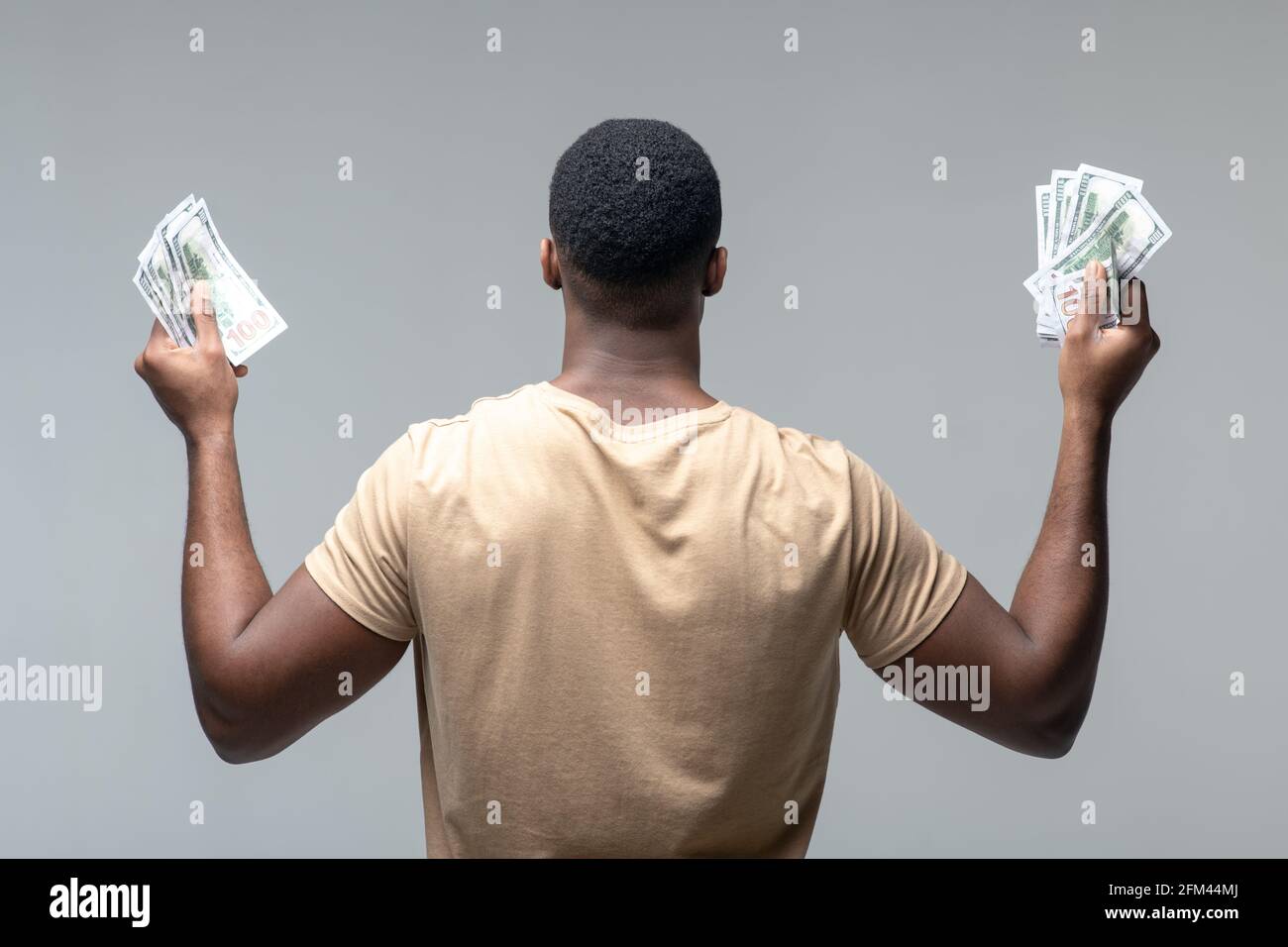 View back of man with banknotes in raised hands Stock Photo - Alamy