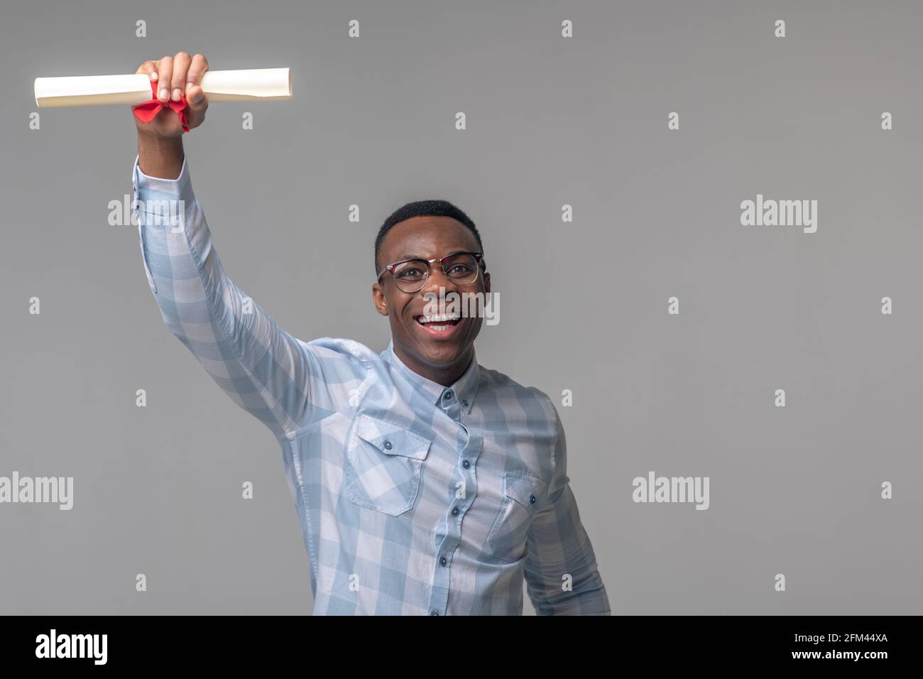 Joyful man raising up hand with paper bundle Stock Photo - Alamy
