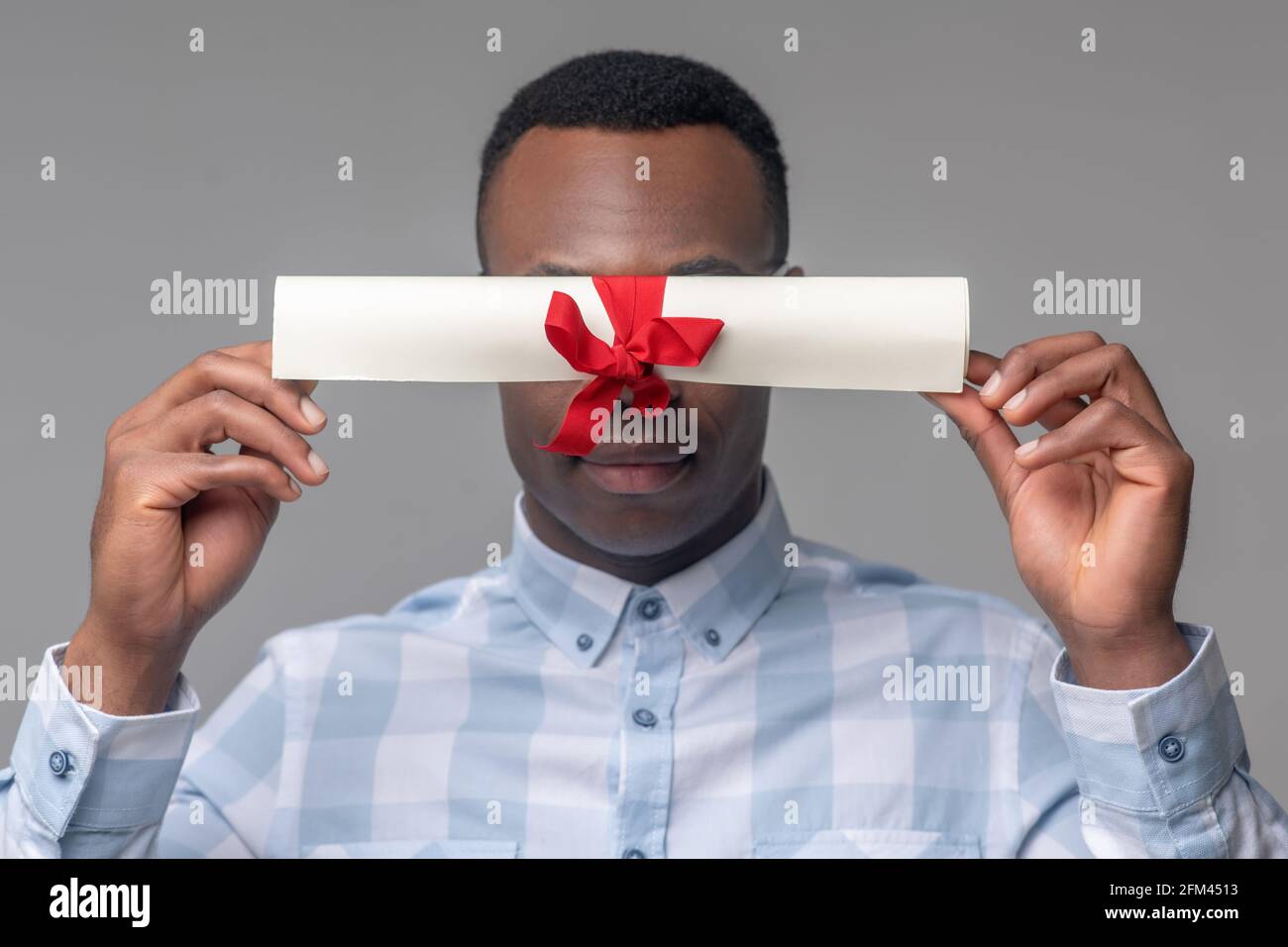 African american holding scroll at face level Stock Photo - Alamy