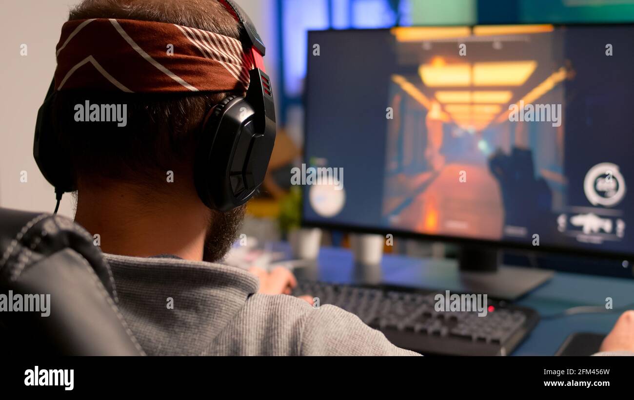 Pro gamer playing on powerful computer first person shooter video game ...