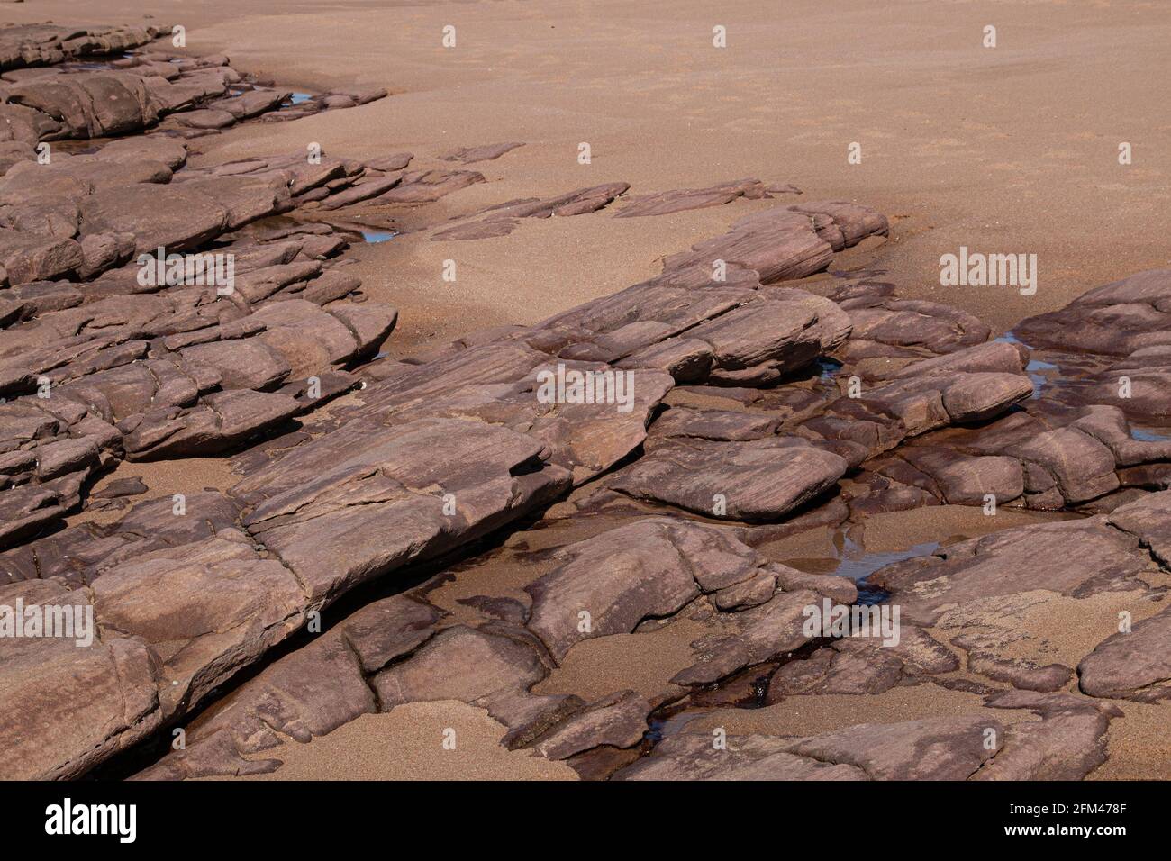 Layers of rocks on beach at low tide Stock Photo - Alamy