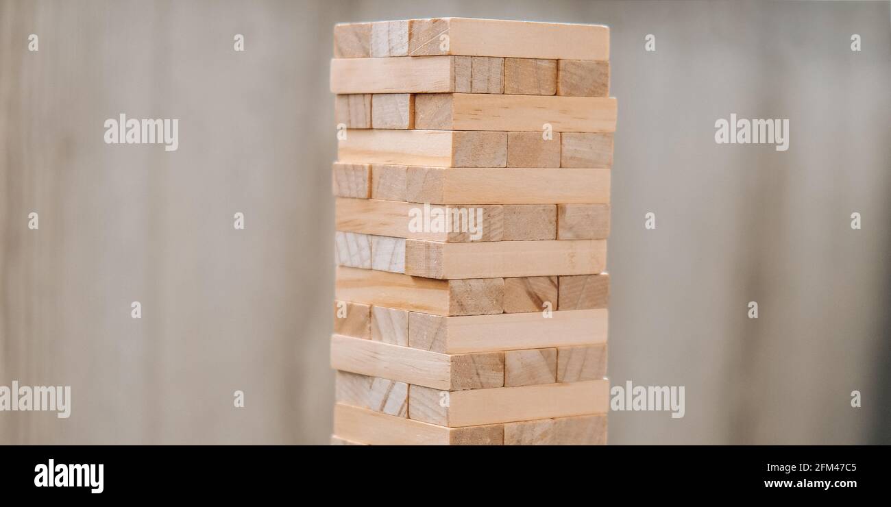 Building from wooden blocks. Game for family of wooden bars. Wood blocks stack game with Hand on ...