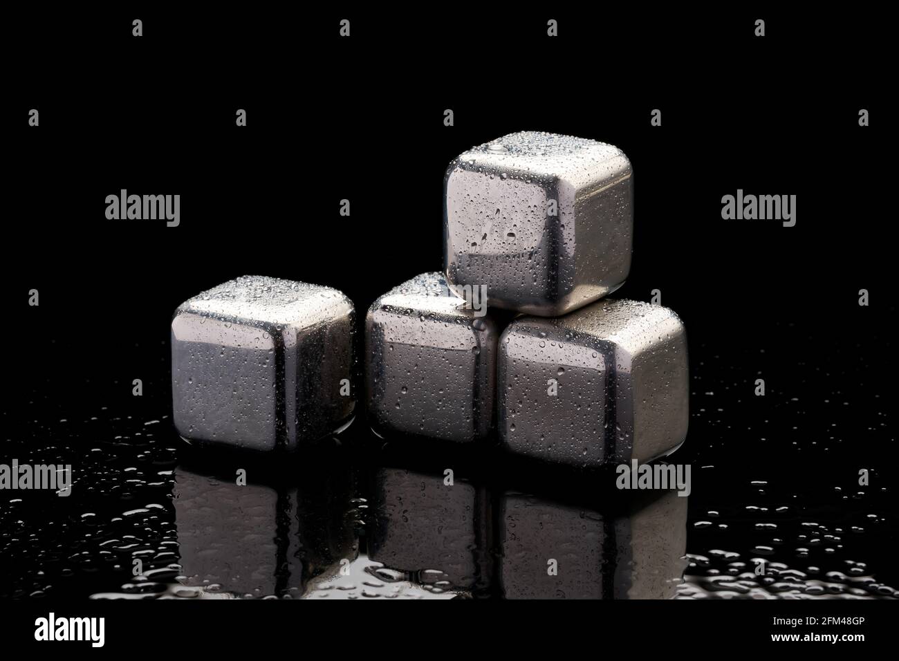 Steel cooling cubes for cocktail drink on glass background Stock Photo ...