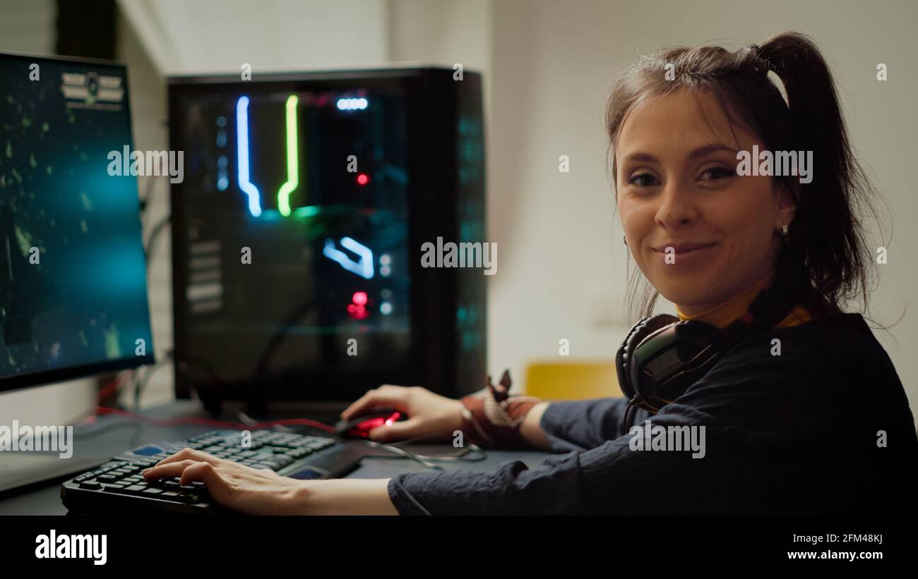 Concentrated gamer looking at camera while playing space shooter online ...