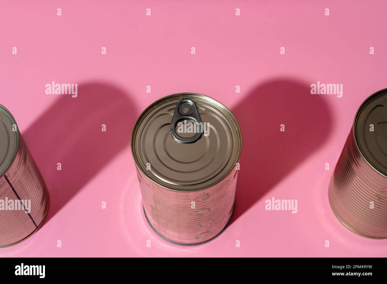 Canned food tin on pink studio background Stock Photo - Alamy