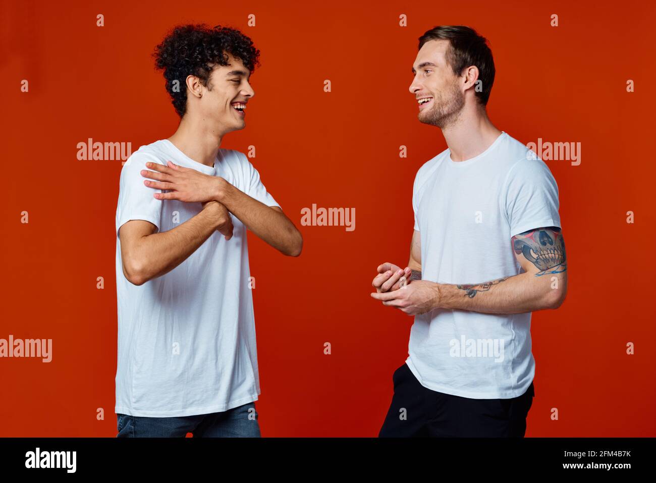 two men stand side by side fun friendship team red background Stock ...