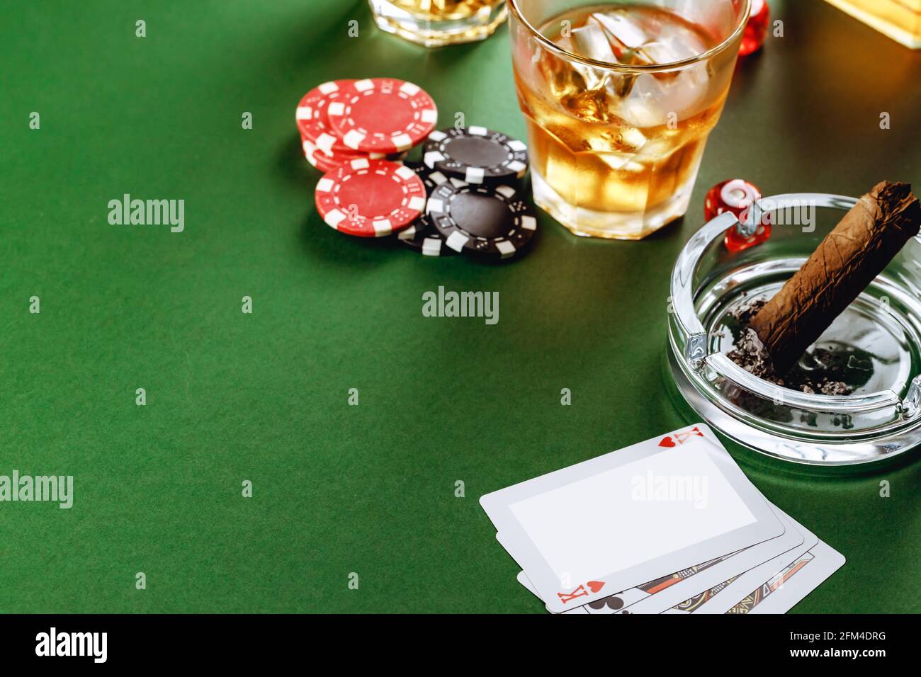 Glass of whiskey, cigar, playing cards and chips on green background ...