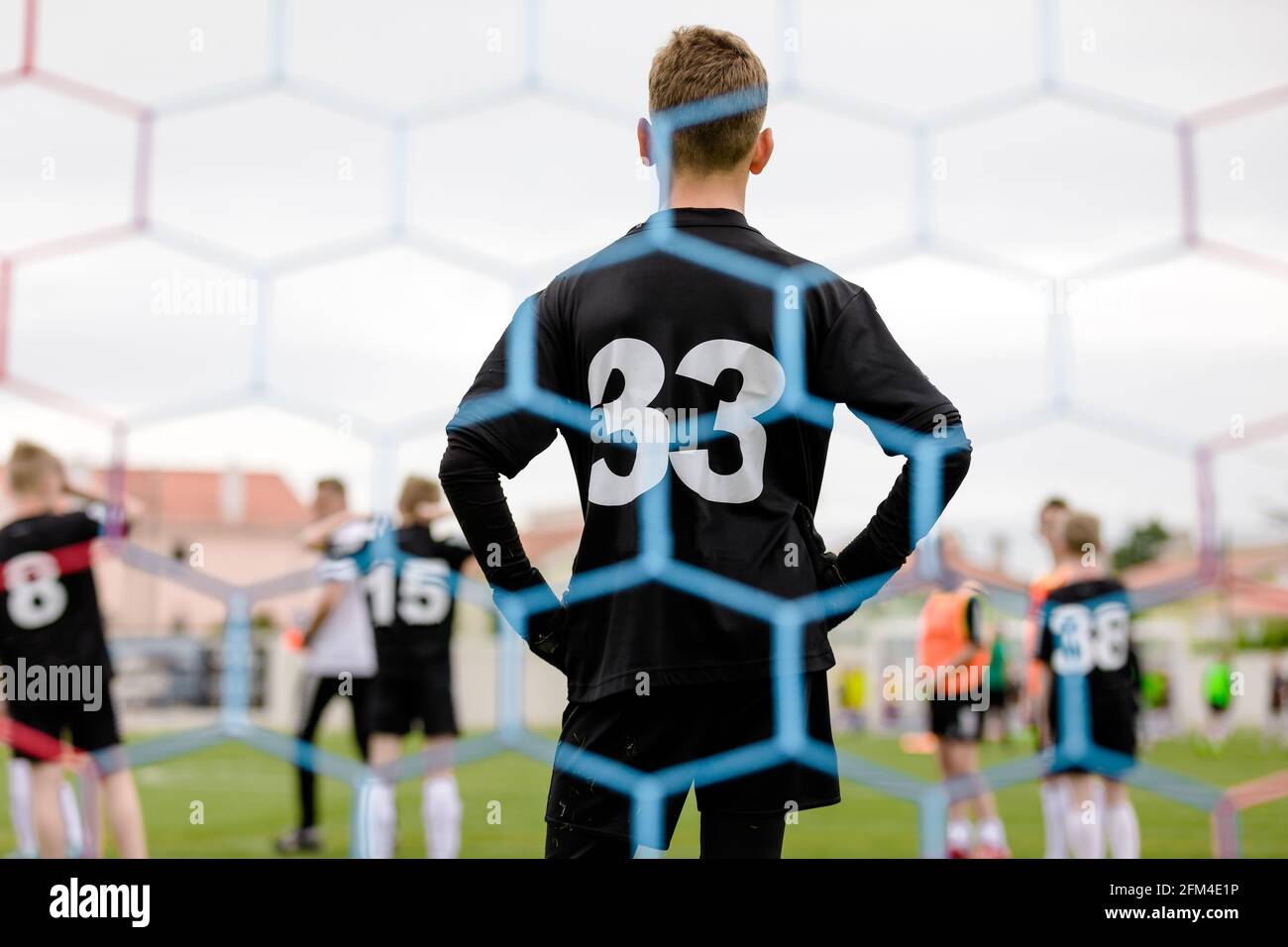 Tall Teenage Goalie Standing in a Goal. Soccer Goal Net in the Blurred ...