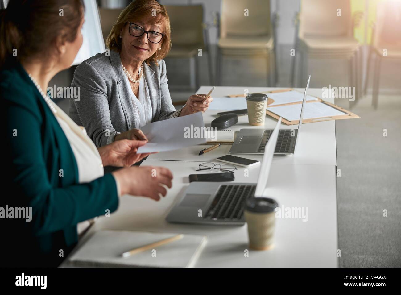 Business owner passing paper sheet to a person Stock Photo - Alamy