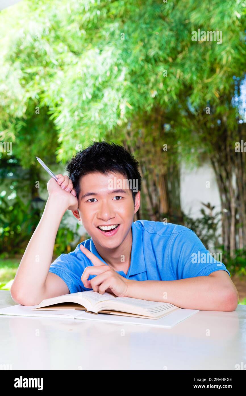 Young Chinese Asian student is successful at home with difficult ...