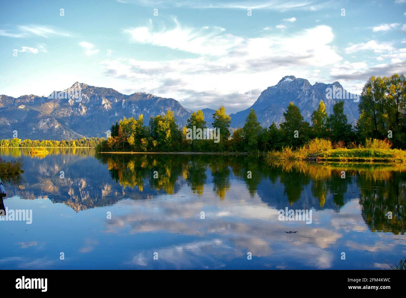Breathtaking view of Lake Forggensee with reflections of trees and ...