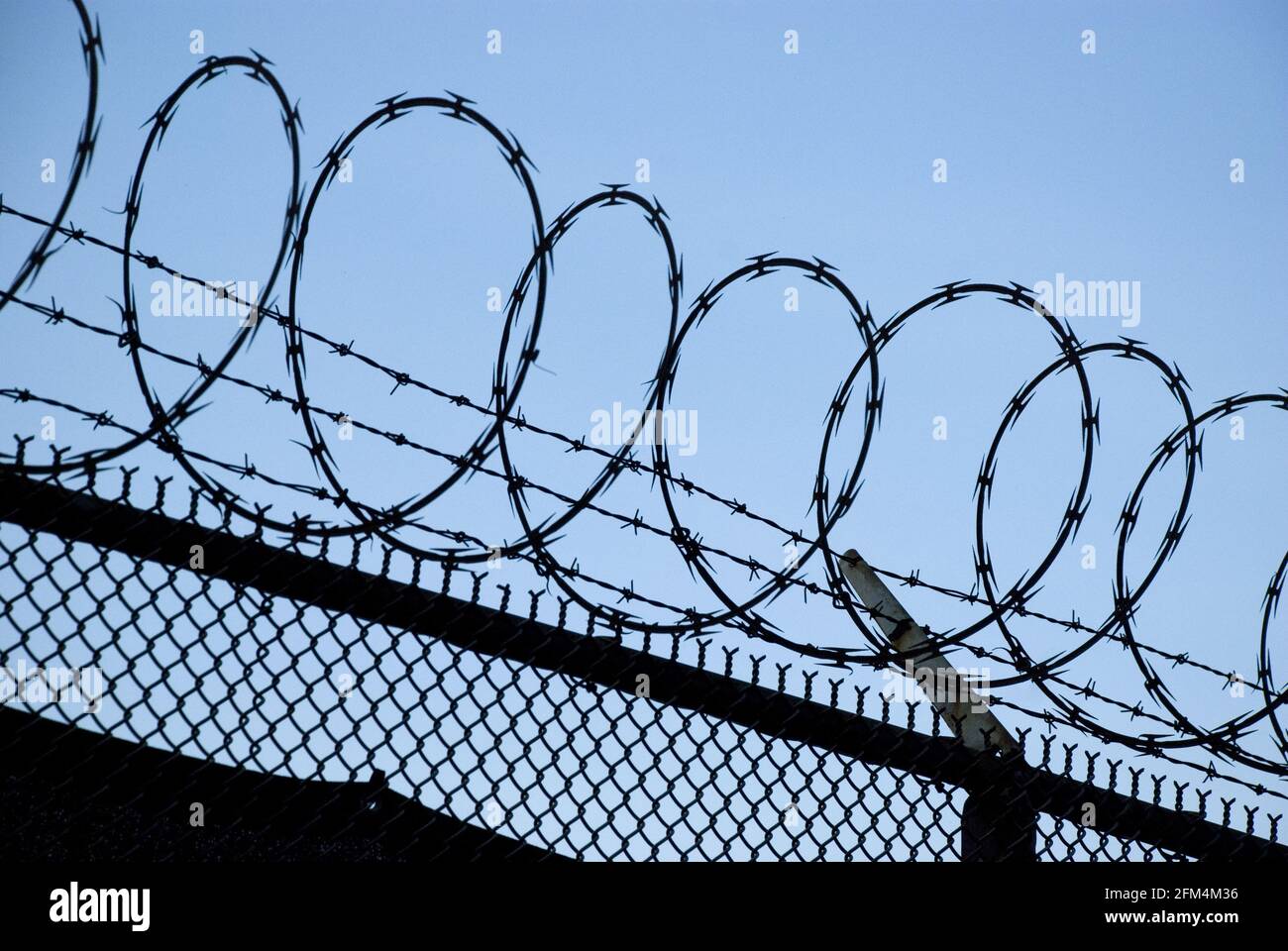barbed wire on top of fence at prison, USA Stock Photo - Alamy