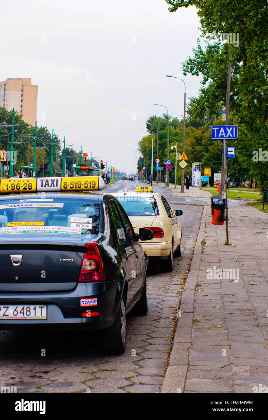 POZN, POLAND - Oct 18, 2015: Row of parked taxis by a sidewalk in the ...