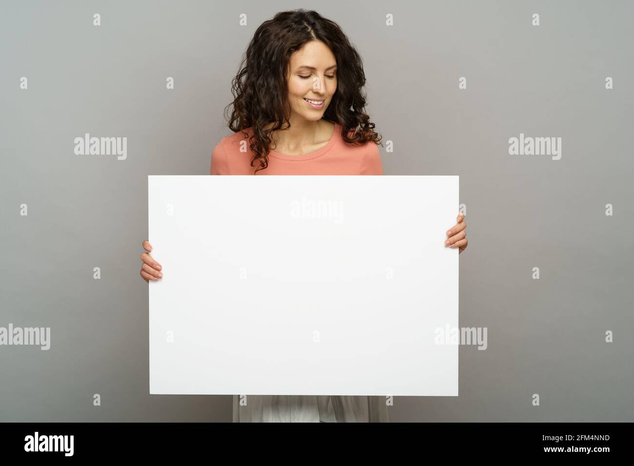 Happy young woman hold blank placard look to copy space with smile ...