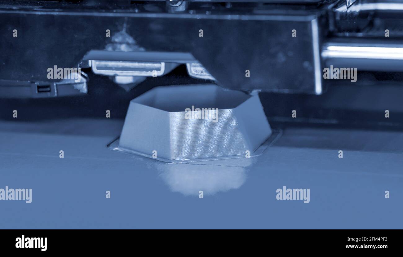 3d printer printing blue gray faceted geometric shapes blue background ...