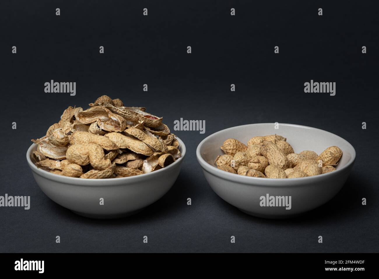 One bowl with peanuts and another one full of peanut shells Stock Photo ...