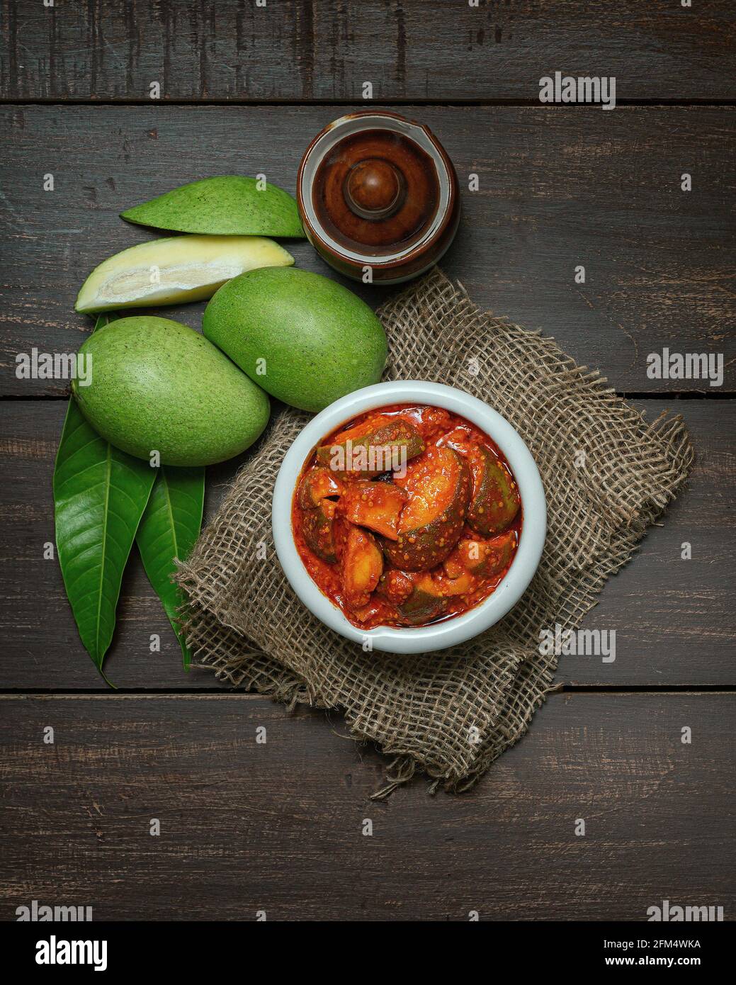 raw mango pickle or aam ka aachar or achar in a white bowl and on a ...
