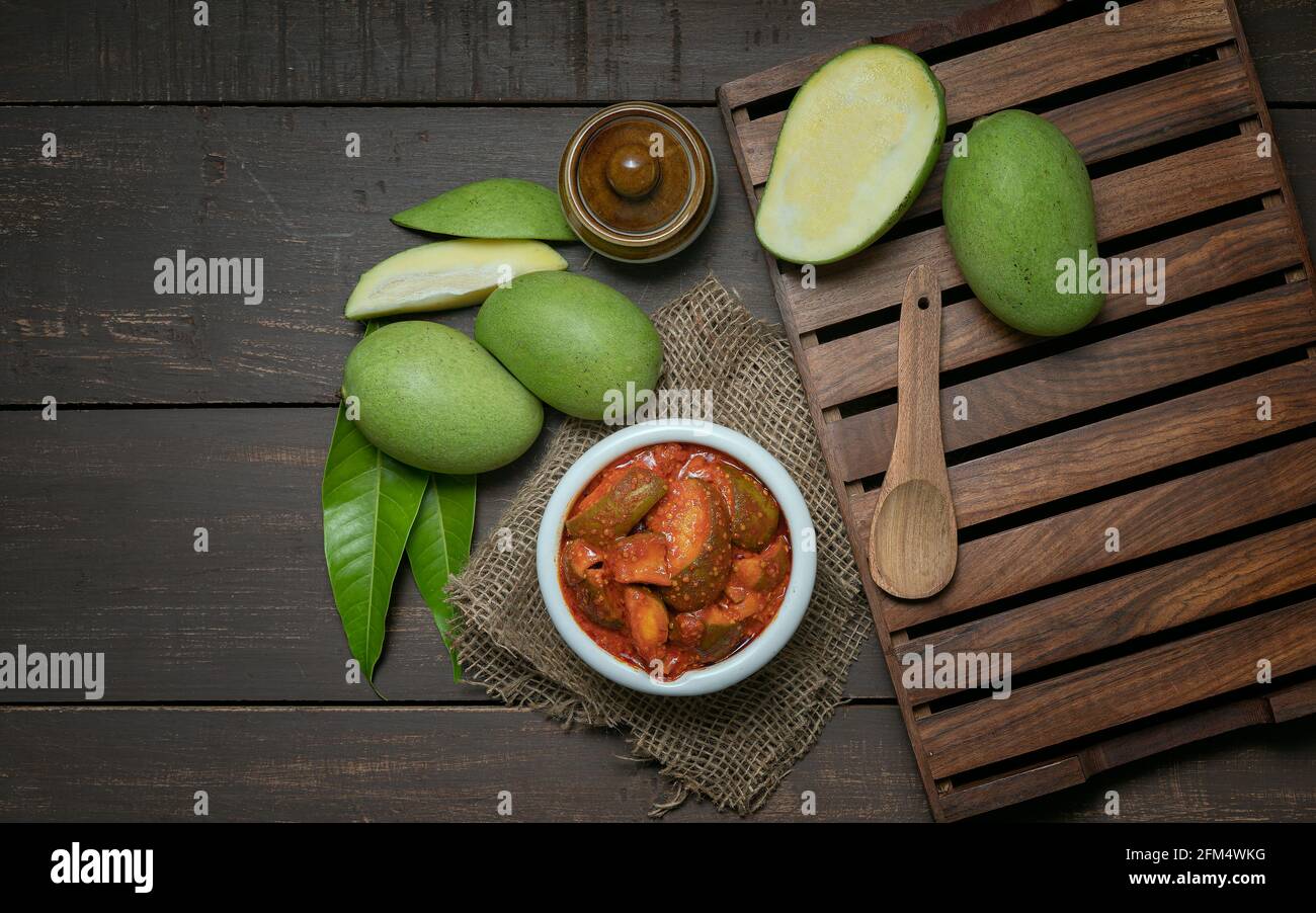 raw mango pickle or aam ka aachar or achar in a white bowl and on a ...