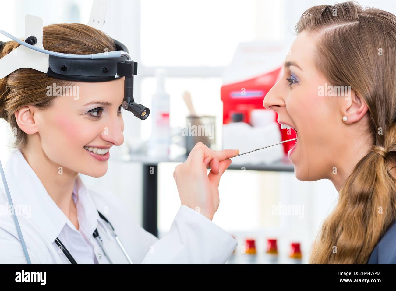 Doctor - Young female doctor or ENT specialist - with a patient in her ...