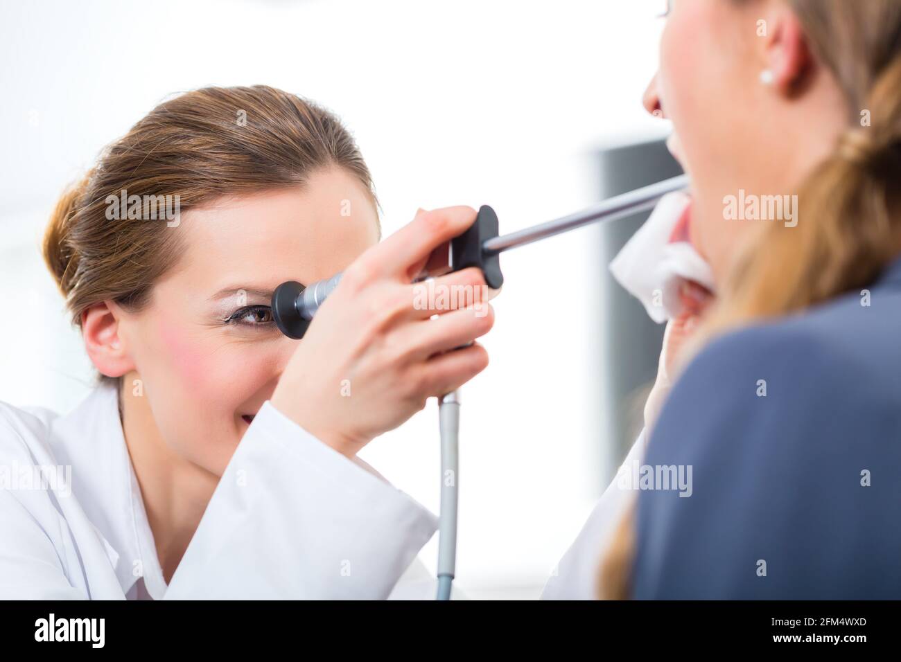 Doctor - Young female consultant or ENT specialist - with a patient in ...