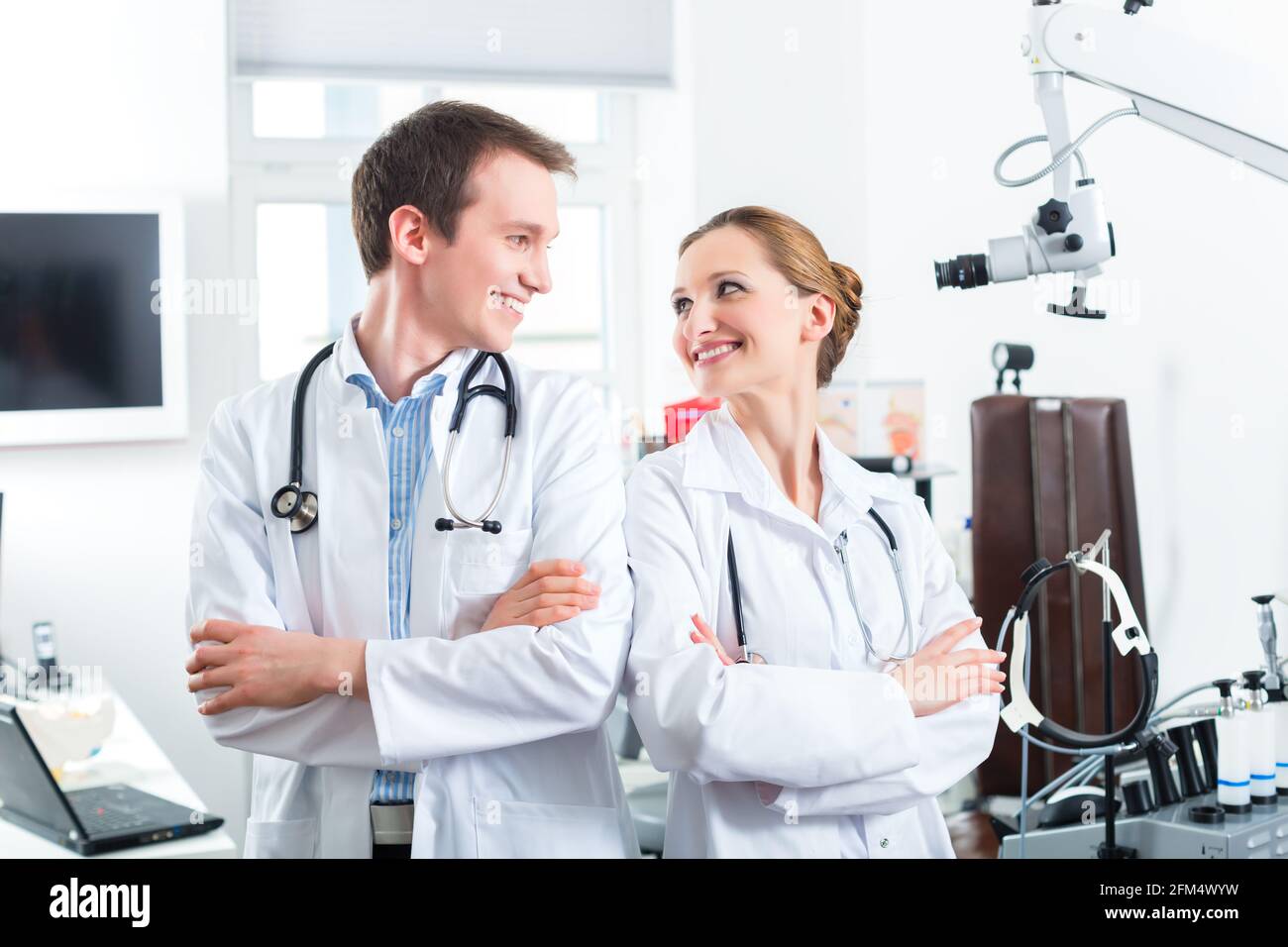 Doctors - male and female, standing with a stethoscope in clinic or ...