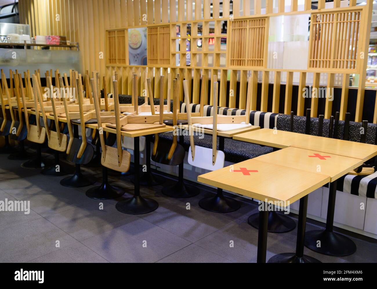 Chairs stacked on tables in an empty closed restaurant during covid-19 ...