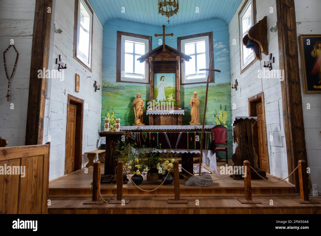 Interior of an old wood church. Blue ceilings, white walls, wooden pews ...