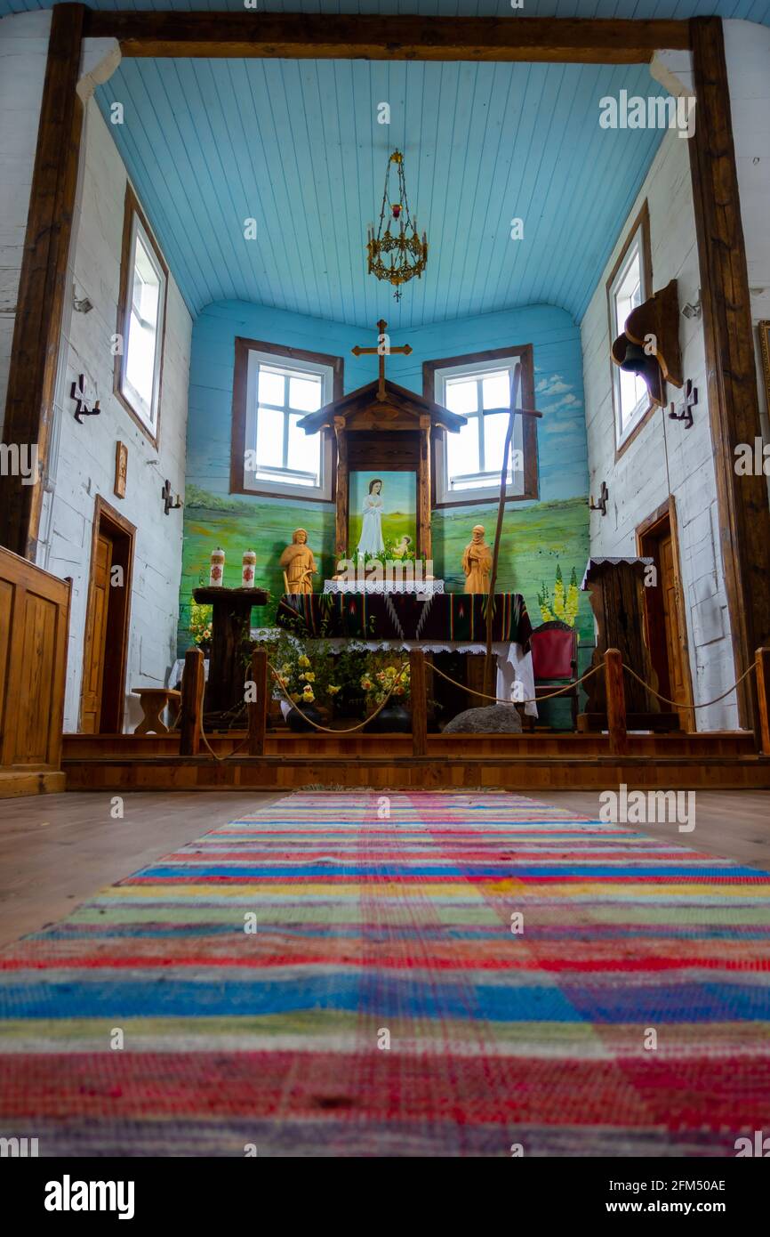 Interior of an old wood church. Blue ceilings, white walls, wooden pews ...