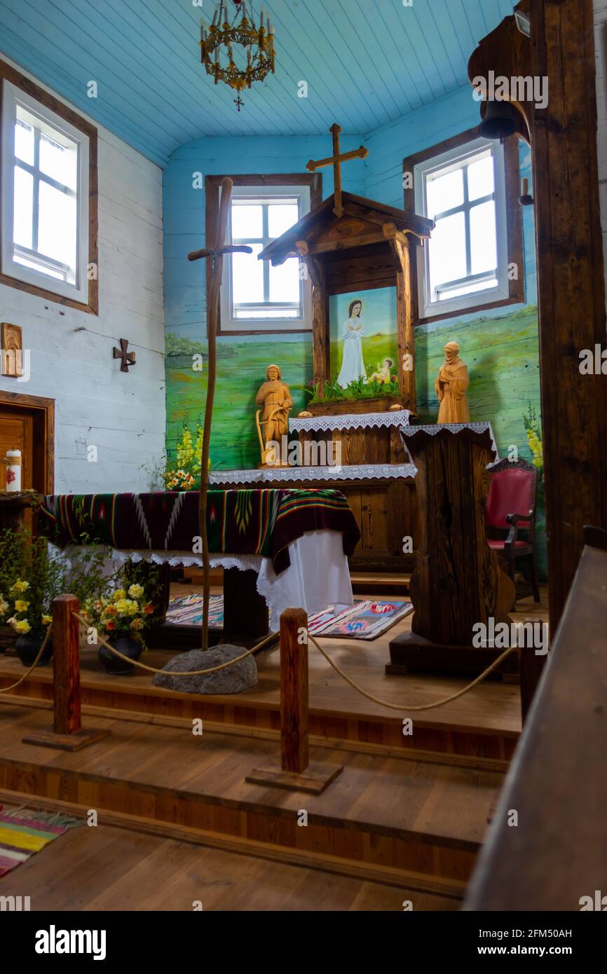 Interior of an old wood church. Blue ceilings, white walls, wooden pews ...
