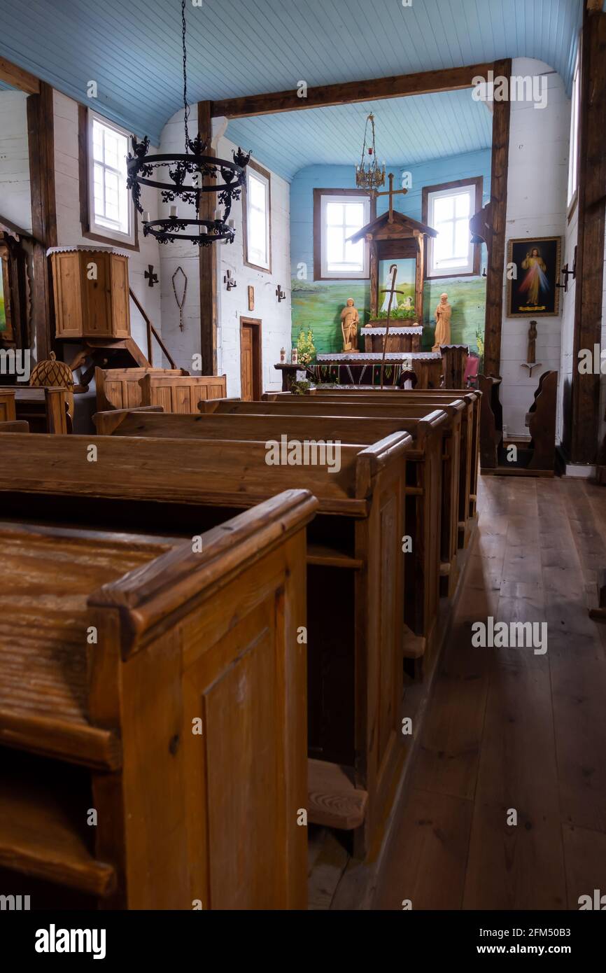 Interior of an old wood church. Blue ceilings, white walls, wooden pews ...