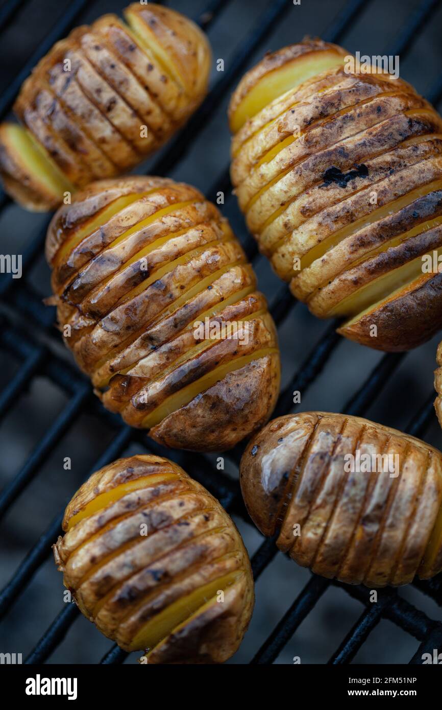 Hasselback potatoes on a bbq grill rack Stock Photo - Alamy