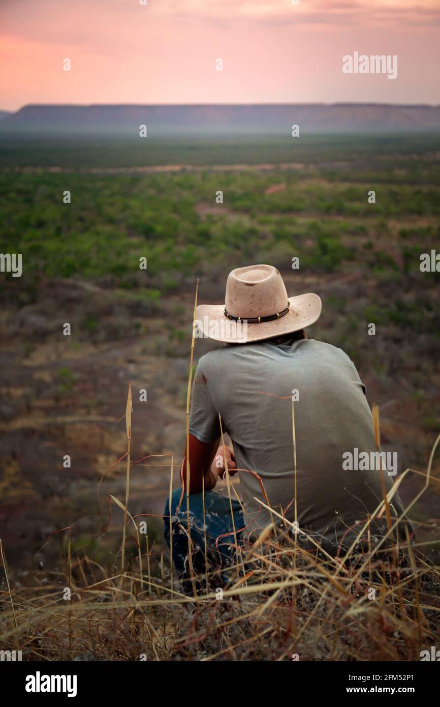 Lonely farmer watching sunset after a long day in the outback, Northern ...