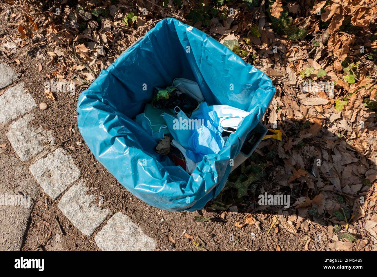 Trash can from above with blue plastic film Stock Photo - Alamy