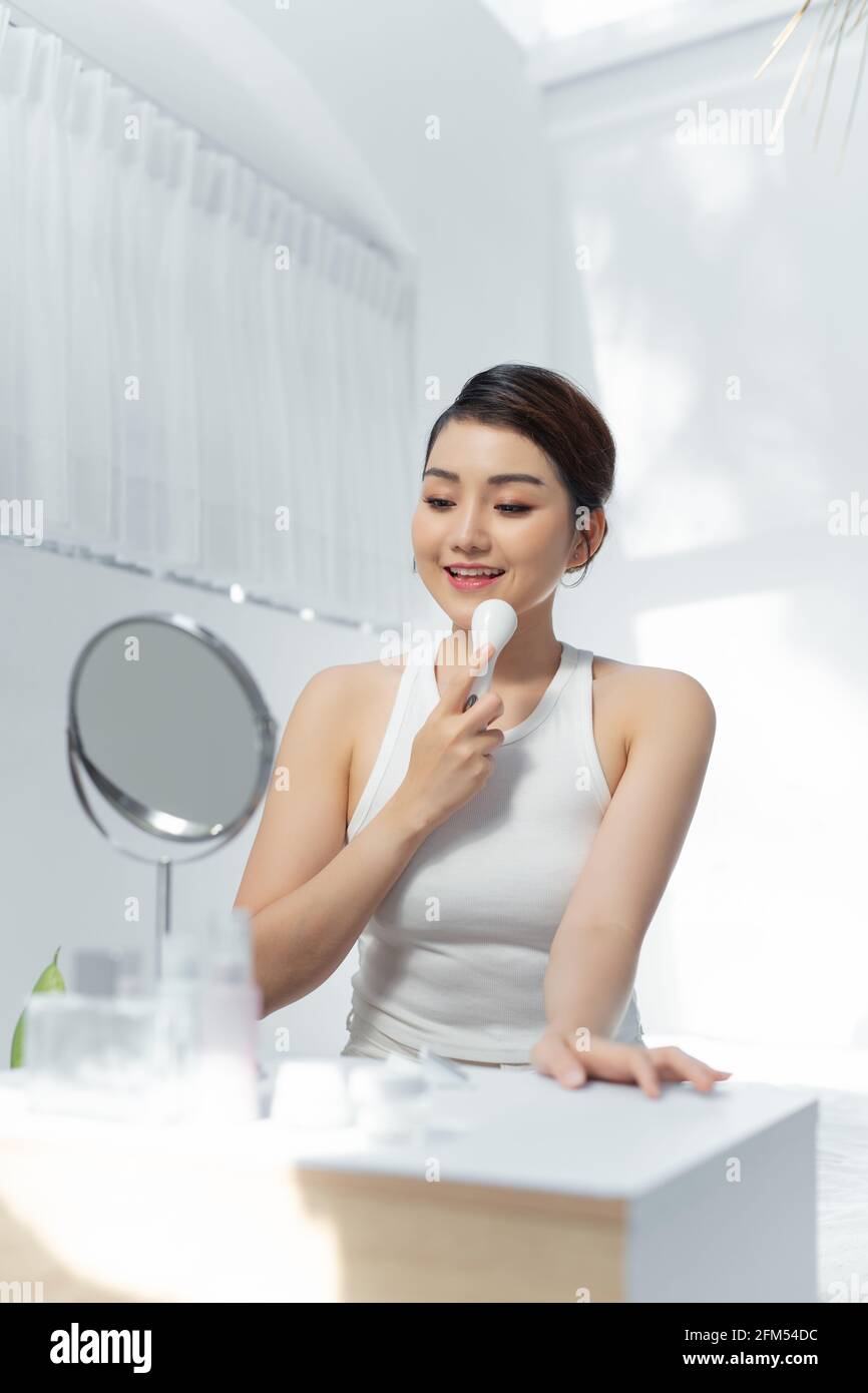 beutiful asian woman doing skin treatment her self at home. galvanic ...
