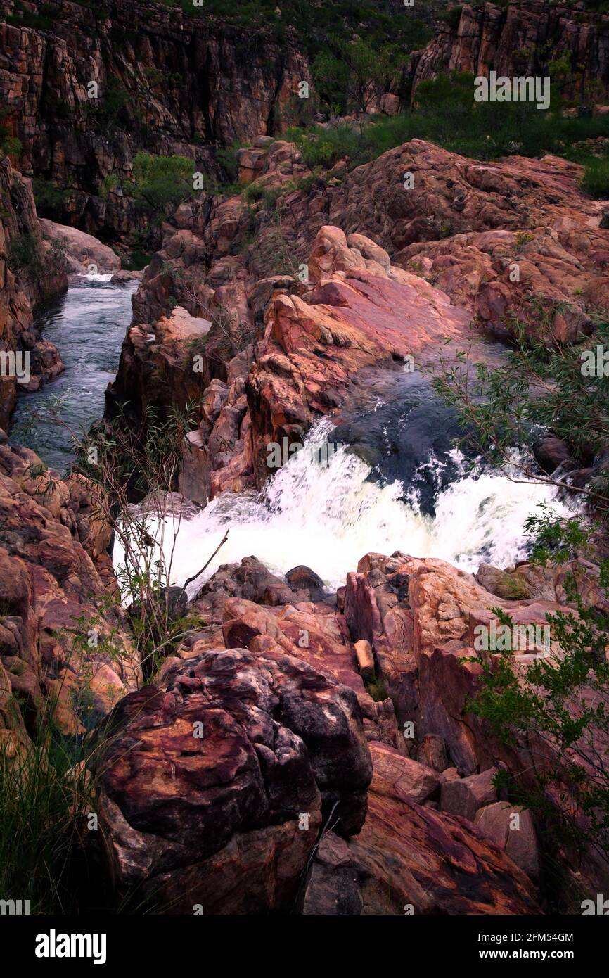 Powerful stream surrounded by red rocks at wet season in Nitmiluk ...