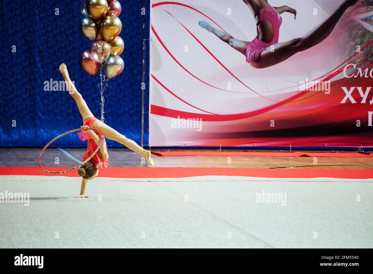 a gymnast girl performs with a hoop. flexible athlete performs a ...